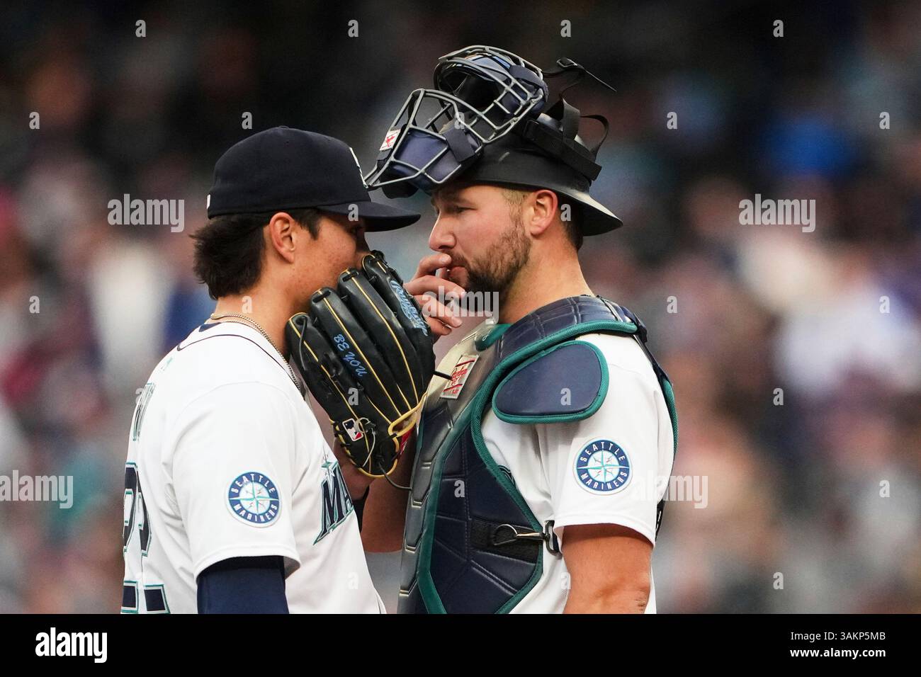 Seattle Mariners starting pitcher Bryan Woo, left, talks with catcher ...