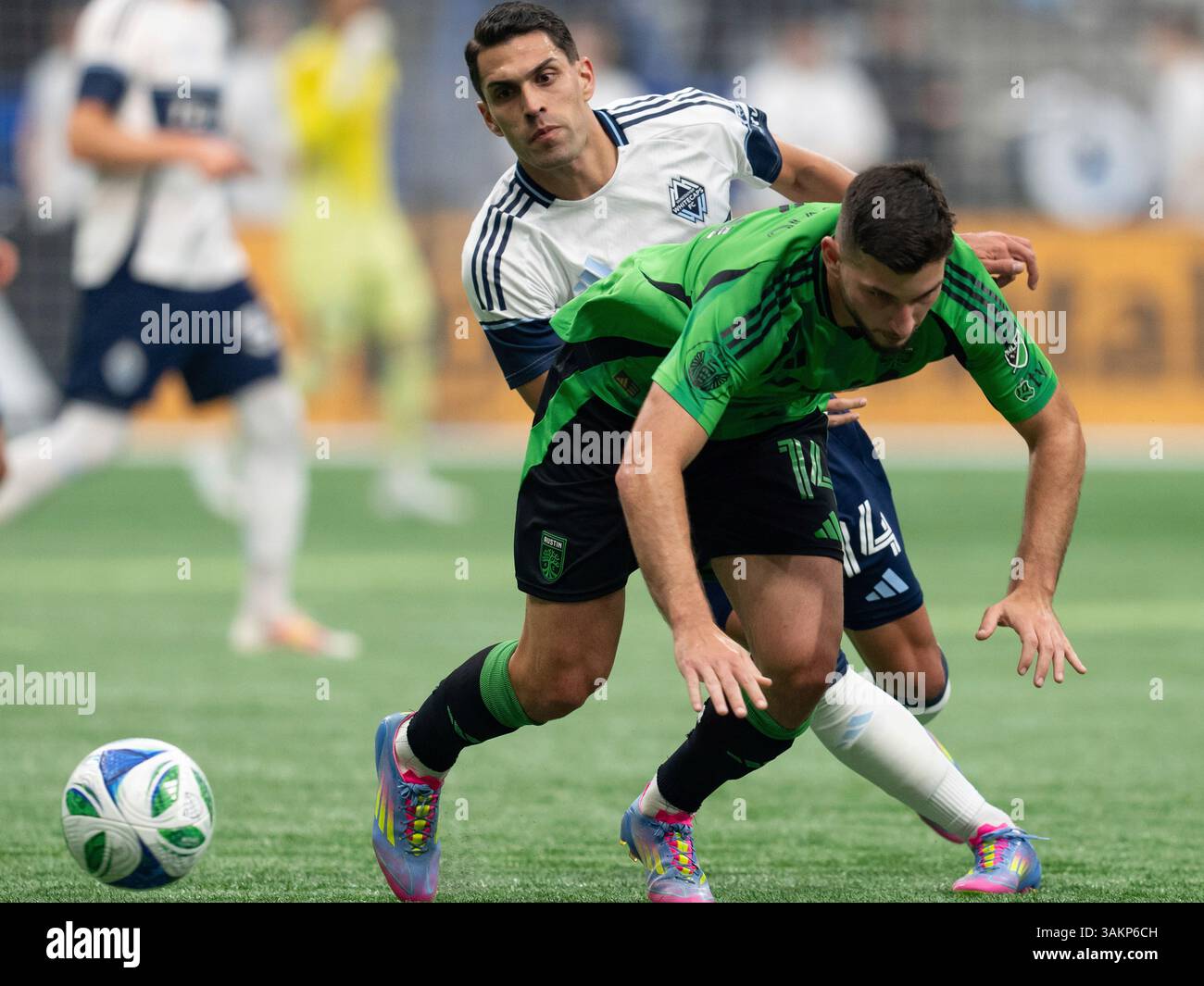 Austin FC's Besard Sabovic, front, trips as he and Vancouver Whitecaps ...