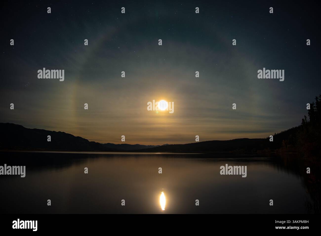 A huge moon dog, halo around the moon with lake reflection and ...