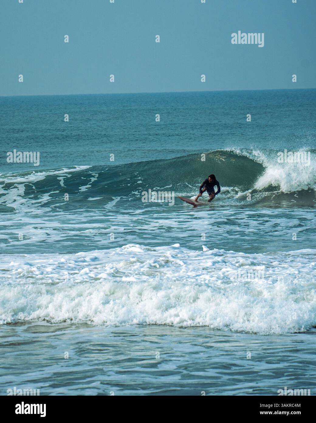 A man surfing a clean wave at Varkala Beach, Kerala, India. Captured on ...