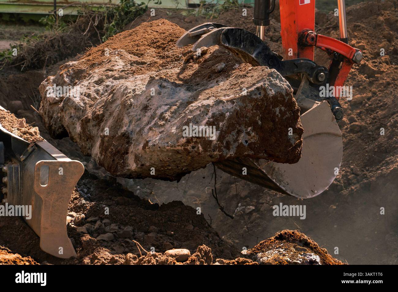 A heavy construction machine, equipped with a claw attachment, is ...