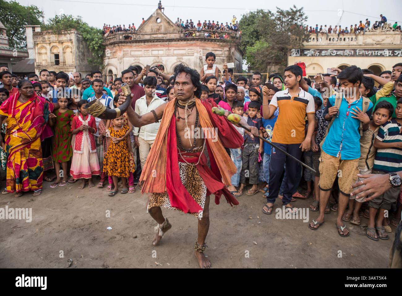 A tribal performer demonstrates a cultural act with props in front of a ...