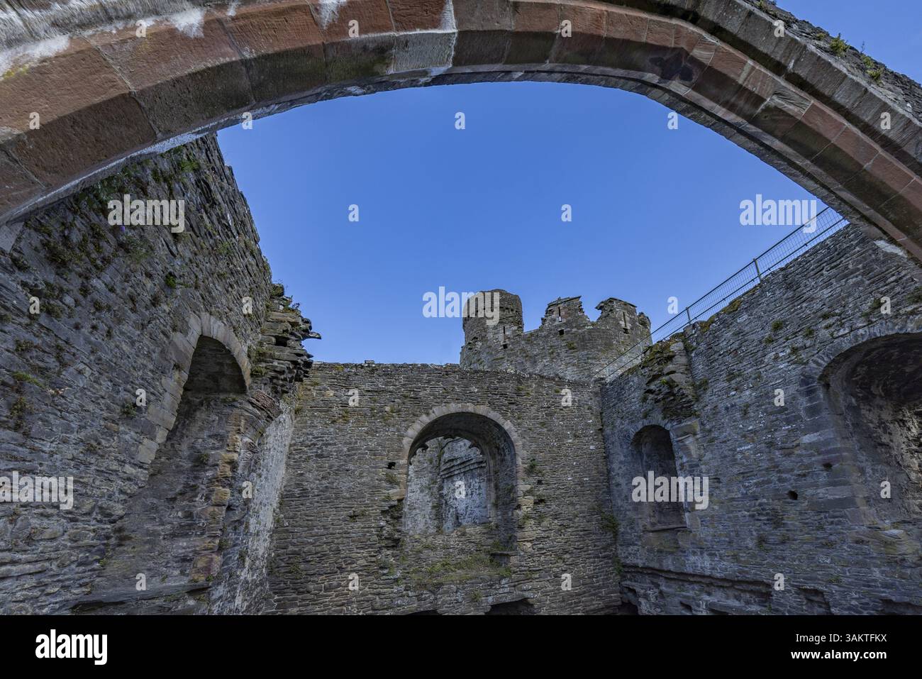 Conwy Castle, ruined stone walls and arch of the castle with a view of ...
