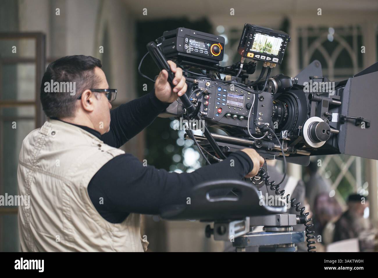 Camera operator with modern professional equipment working during film ...