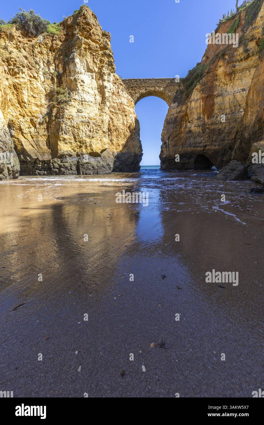 Yellow rocks and cliffs on a sandy beach. A bay by the sea, over which ...