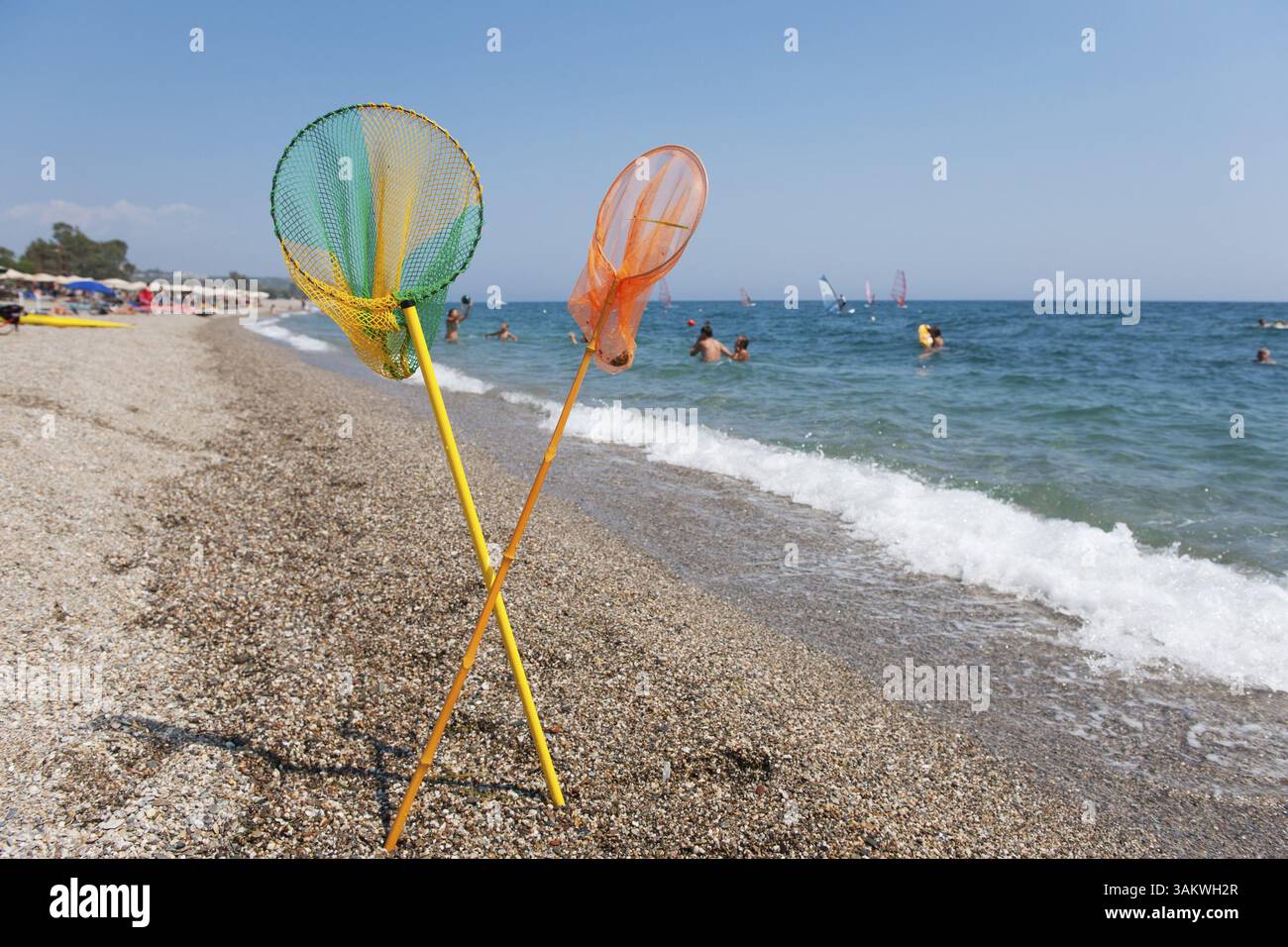 Beach vacation with fishing nets and swimming people Stock Photo - Alamy