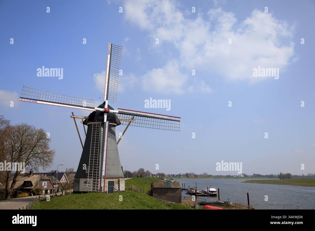 Dutch Windmill in river landscape Stock Photo - Alamy