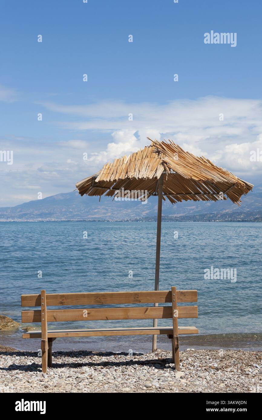 Vertical landscape of Greek beach with empty bench Stock Photo - Alamy