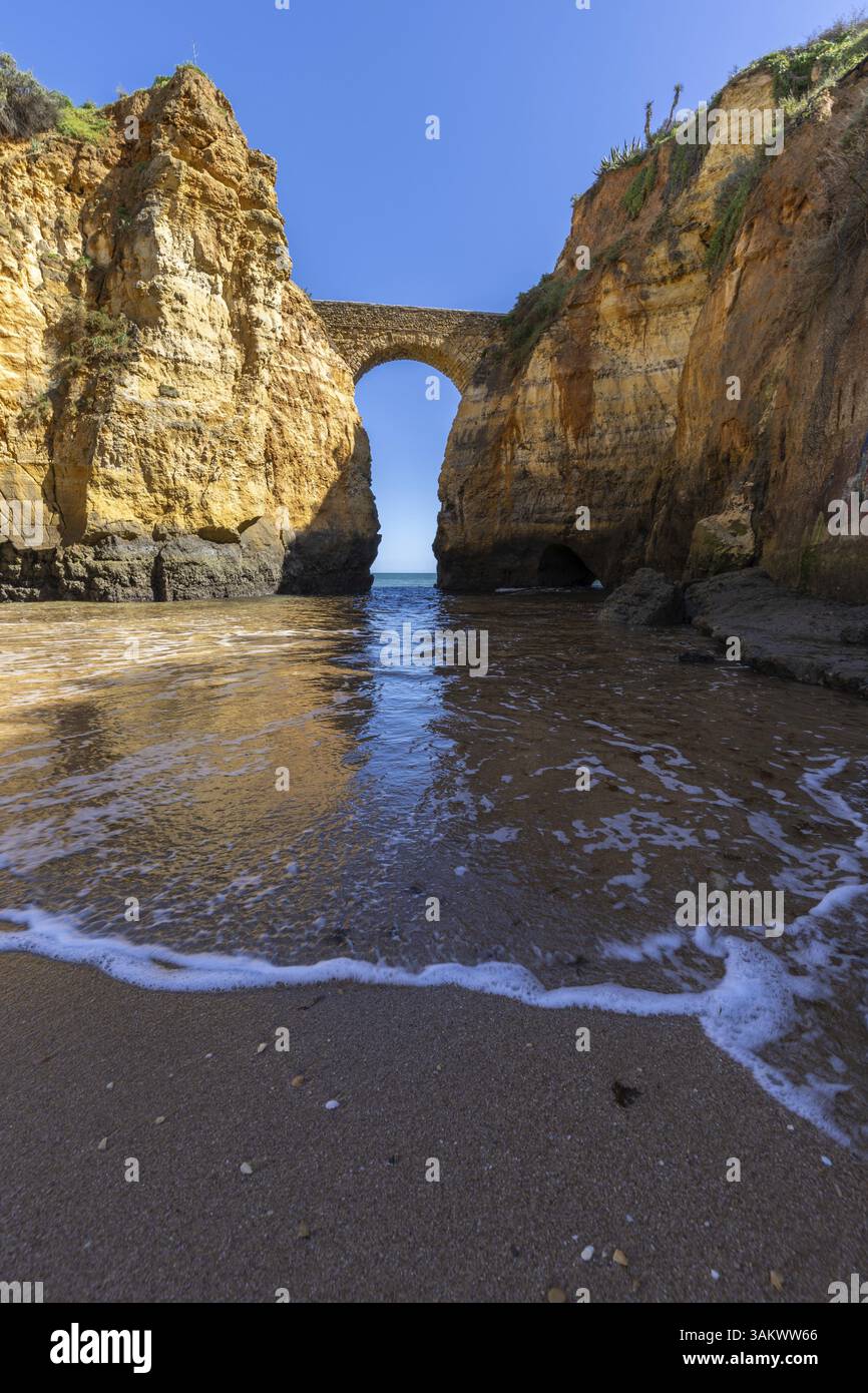 Yellow rocks and cliffs on a sandy beach. A bay by the sea, over which ...