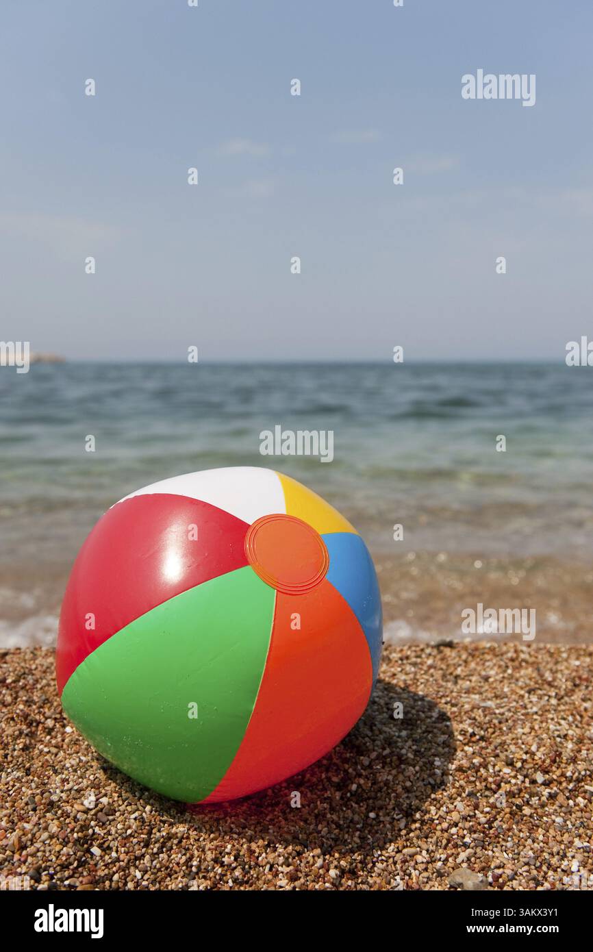Beach ball near the sea in landscape Stock Photo - Alamy