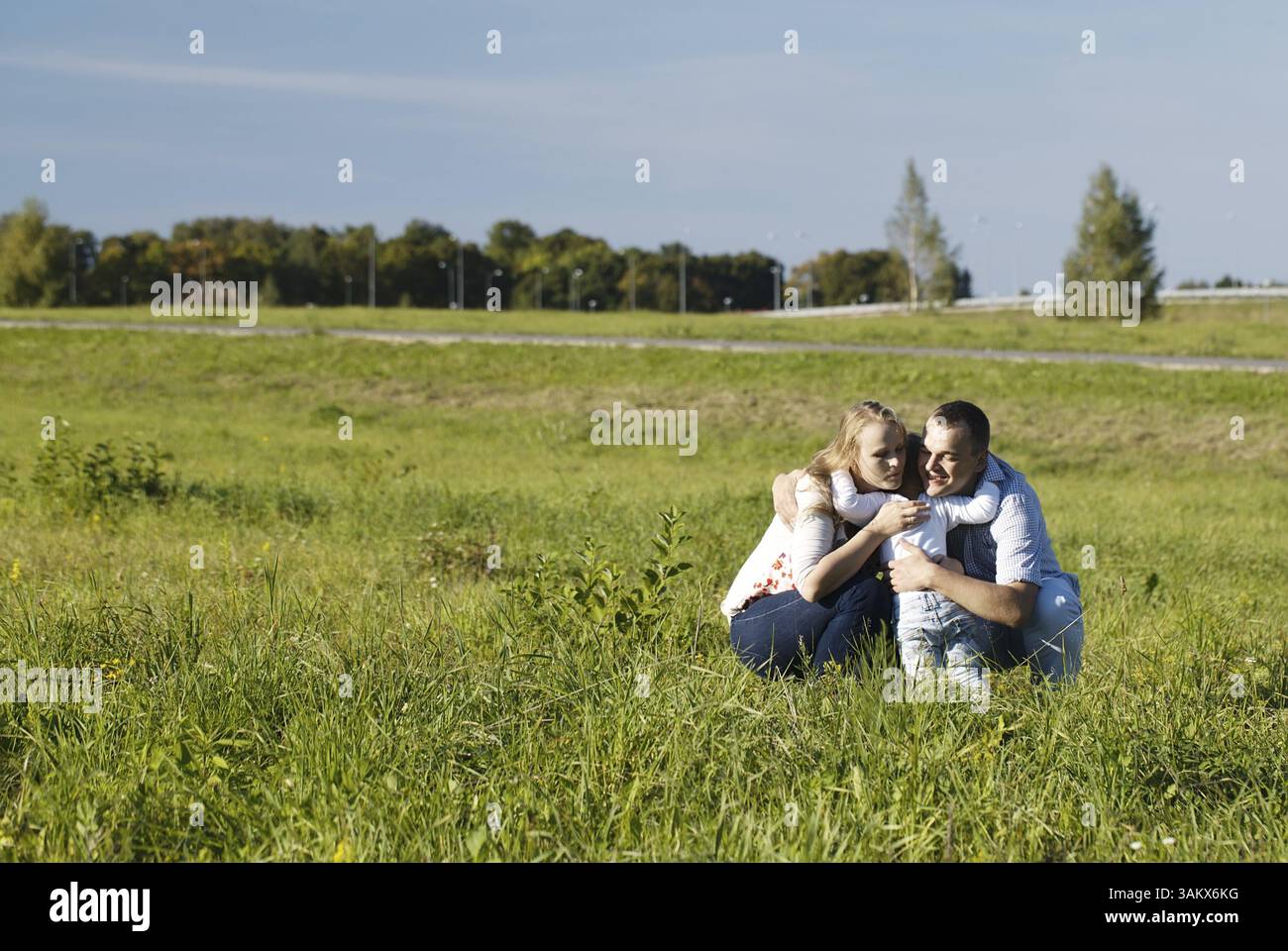 Mother, father and their little son having fun in the countryside. Son ...