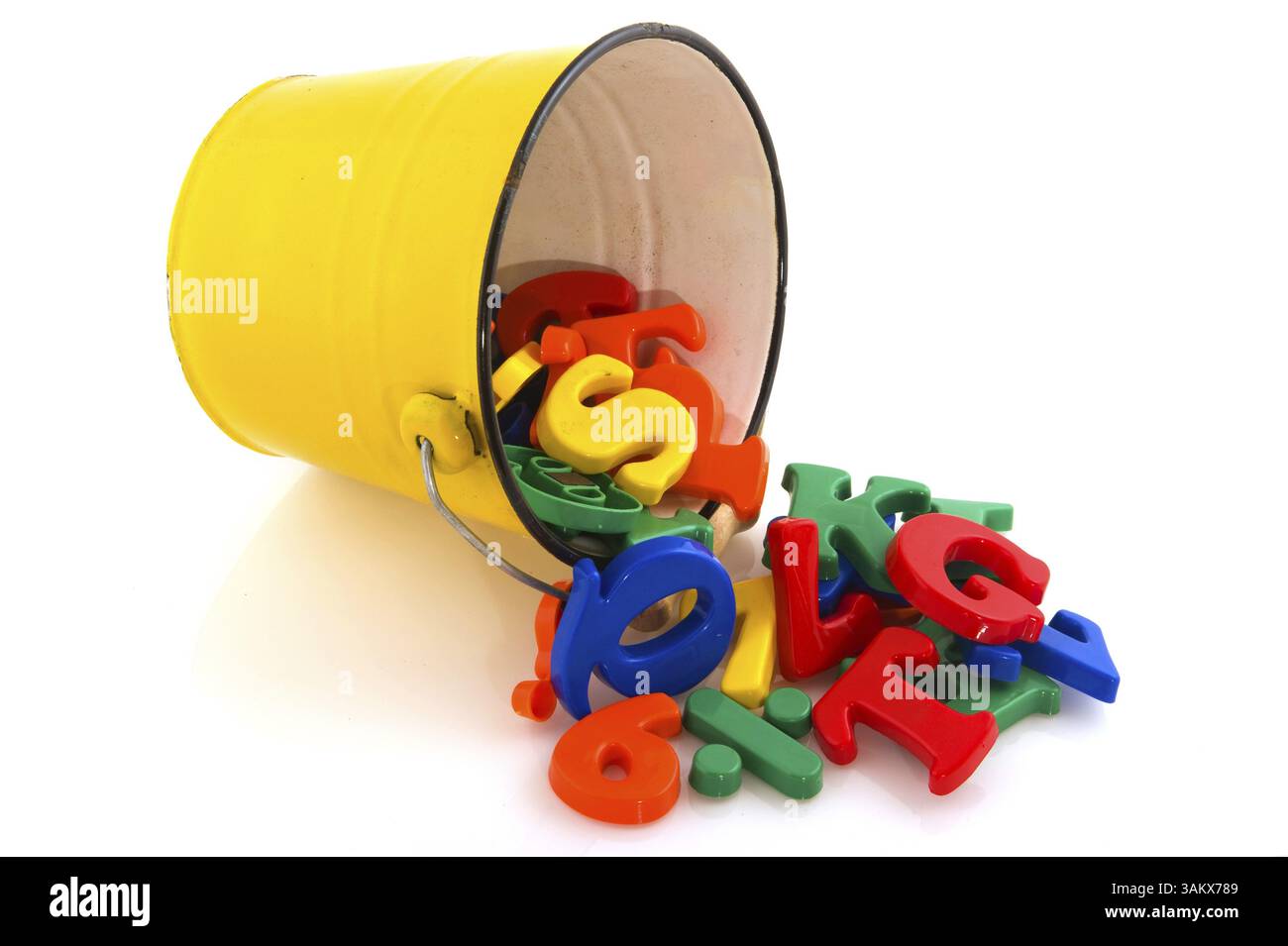 Fallen bucket with plastic ciphers and letters isolated over white ...