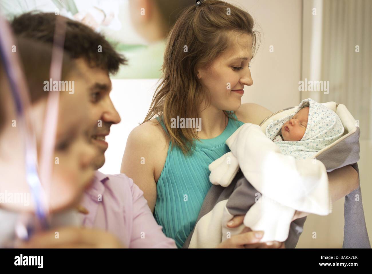 Side view of a happy family in the maternity hospital, father holds ...