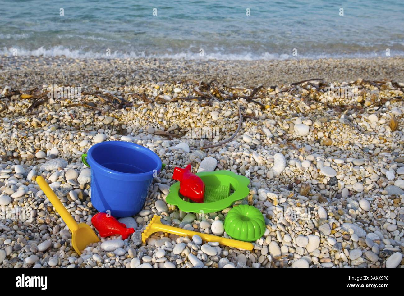 Beach with pebbles and toys Stock Photo - Alamy