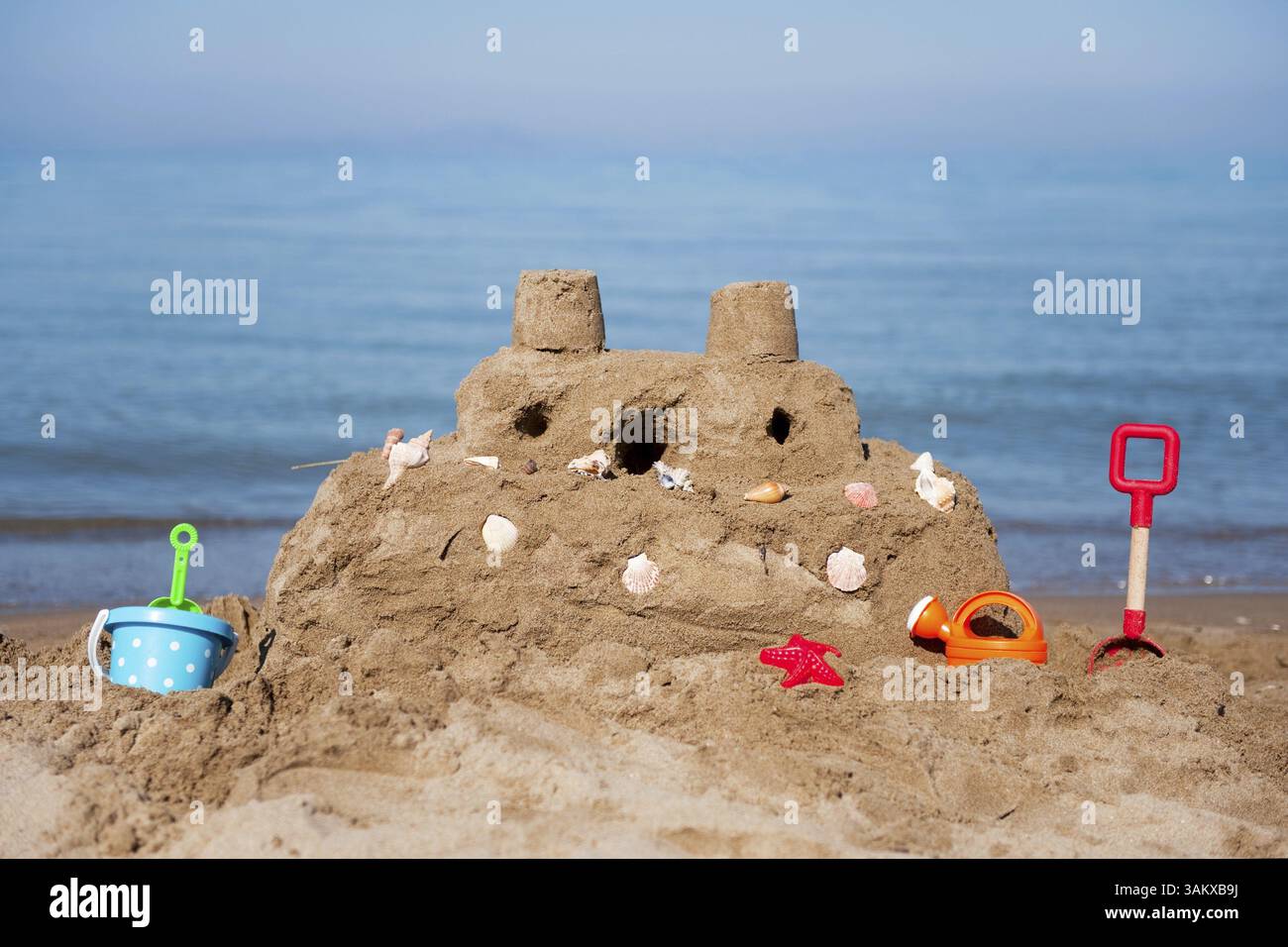 Sand castle at the beach with plastic toys Stock Photo - Alamy