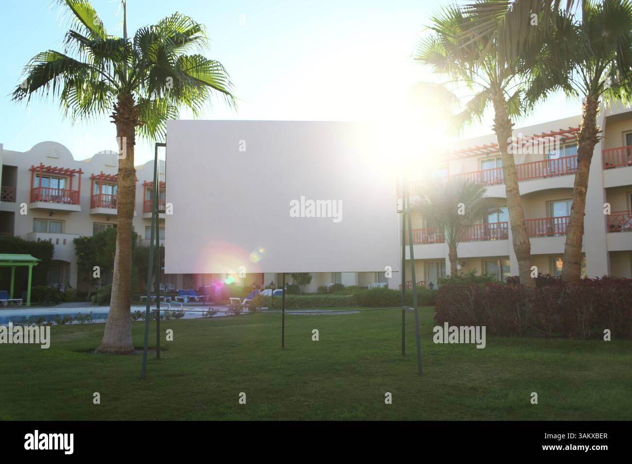 Sun flare behind a blank urban billboard for your ads standing between ...