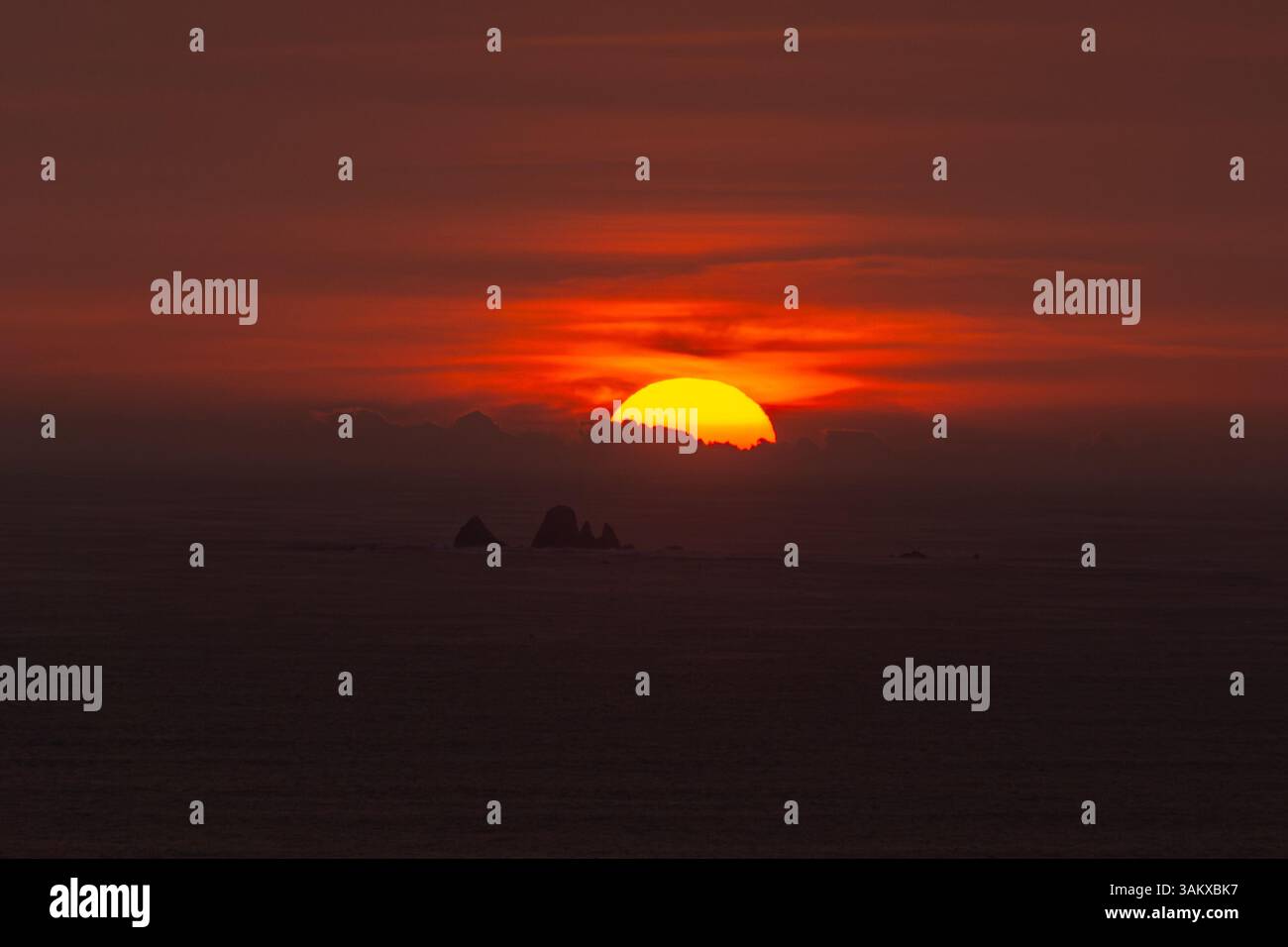 Sun setting in the Pacific Ocean over a retreating fog bank Stock Photo ...