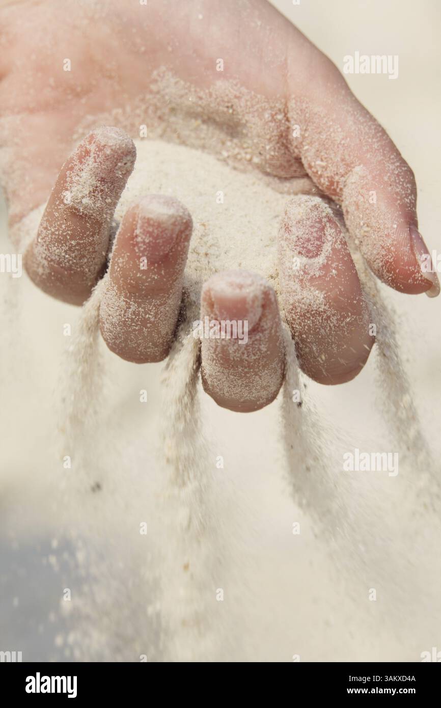 Sand fall through fingers Stock Photo - Alamy