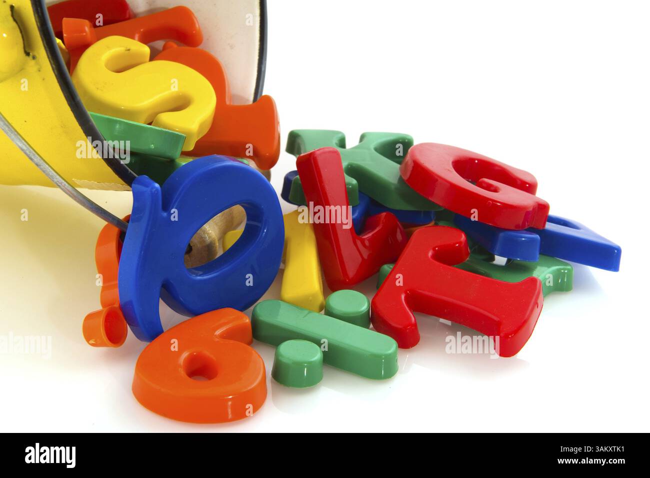 Fallen bucket with plastic ciphers and letters isolated over white ...