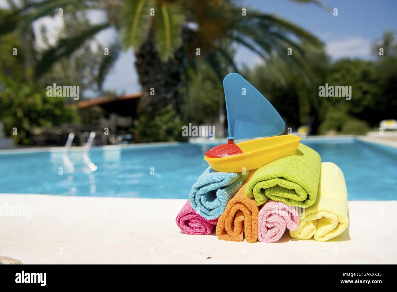 Rolled towels and plastic boat near the swimming pool Stock Photo - Alamy