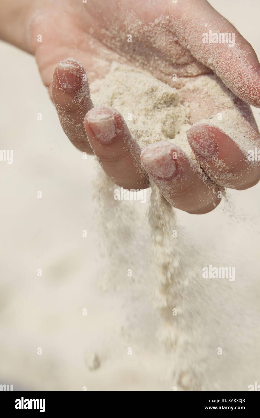 Sand fall through fingers Stock Photo - Alamy