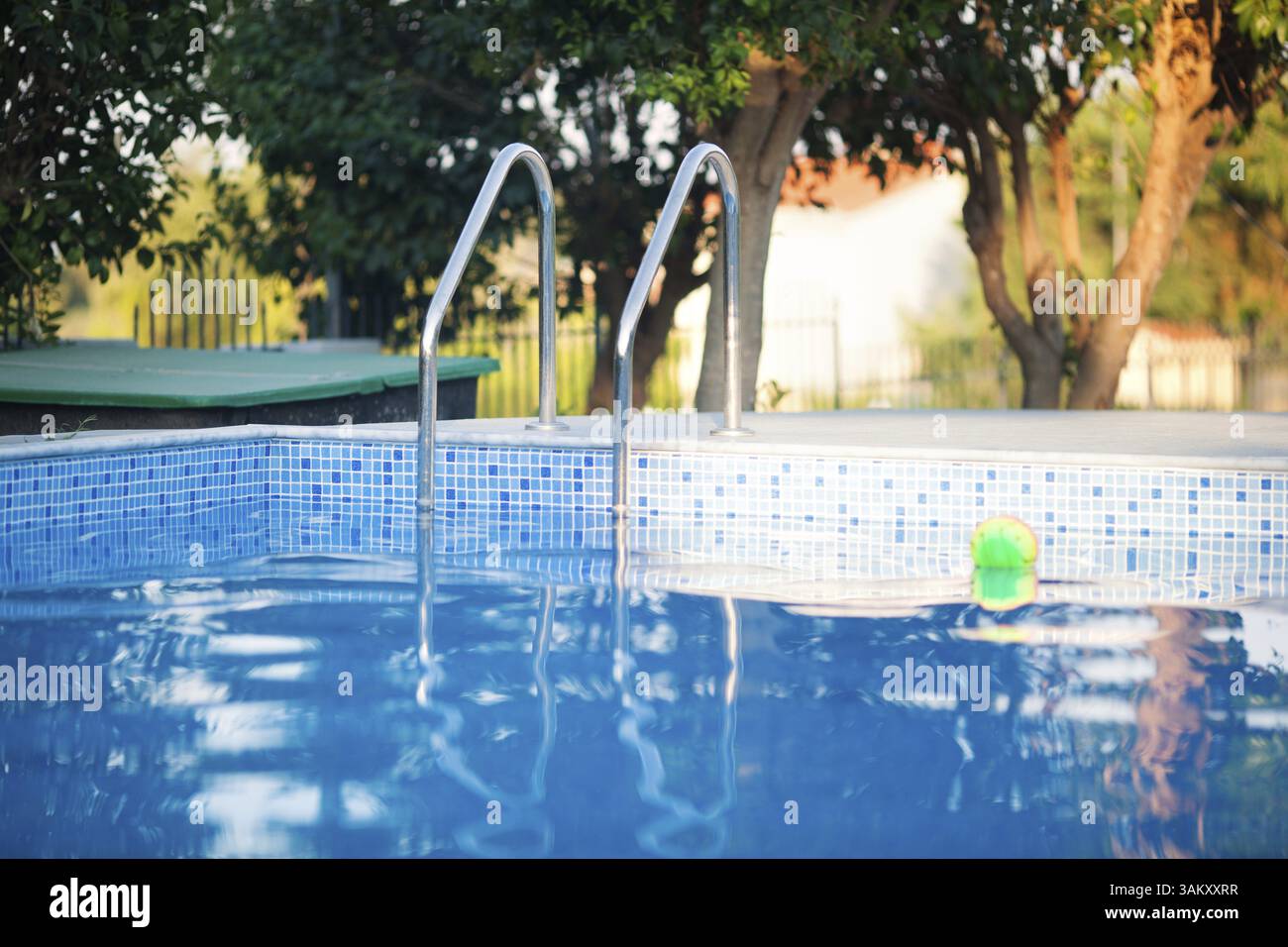 Outdoor swimming pool with clean water, tiled blue walls and stainless ...