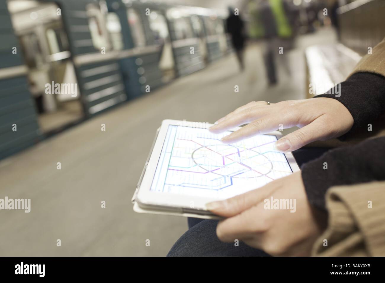 Close-up shot of woman using tablet computer in subway. She looking at ...