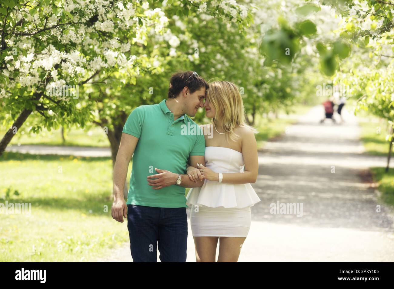Beautiful couple having a stroll in park at spring Stock Photo - Alamy