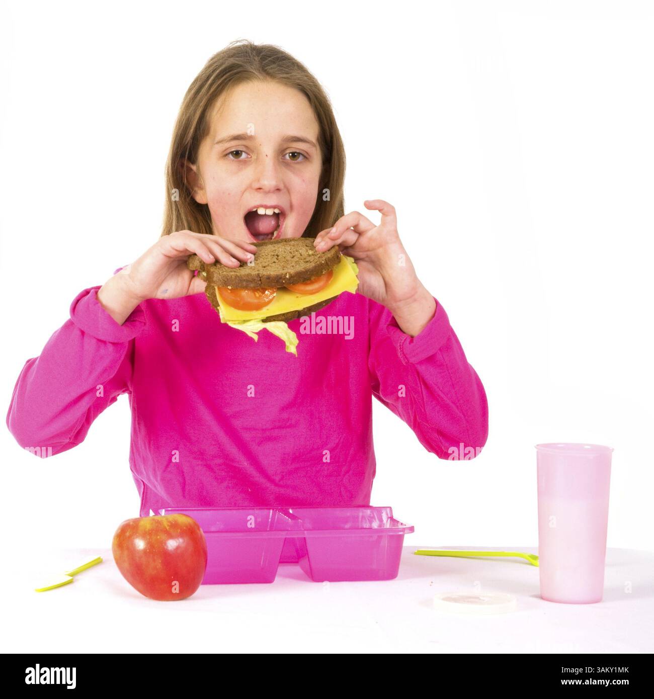 School girl is eating a healthy lunch with fruit and whole meal bread ...