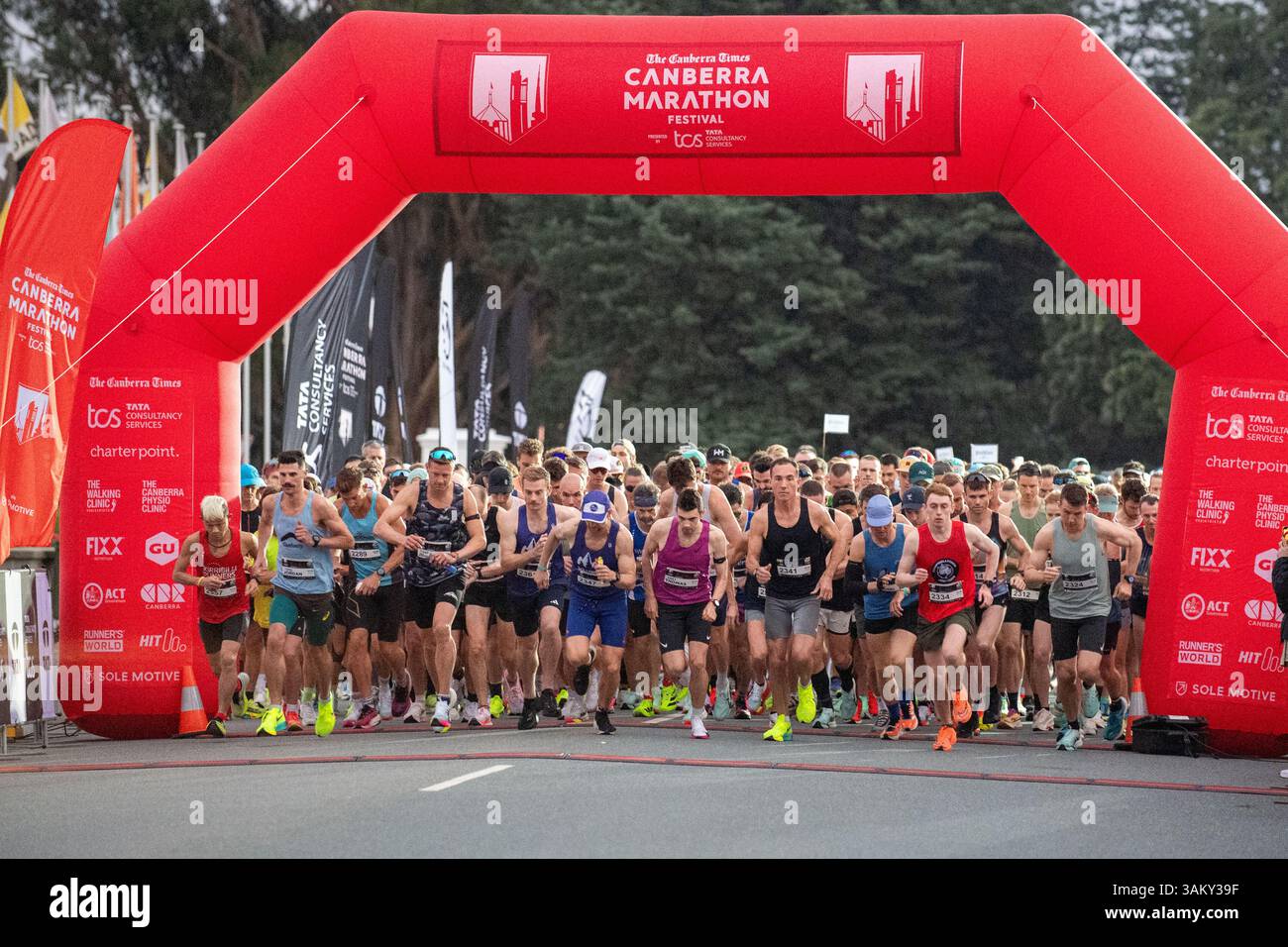 Competitors surge forward from the starting line at the beginning of ...