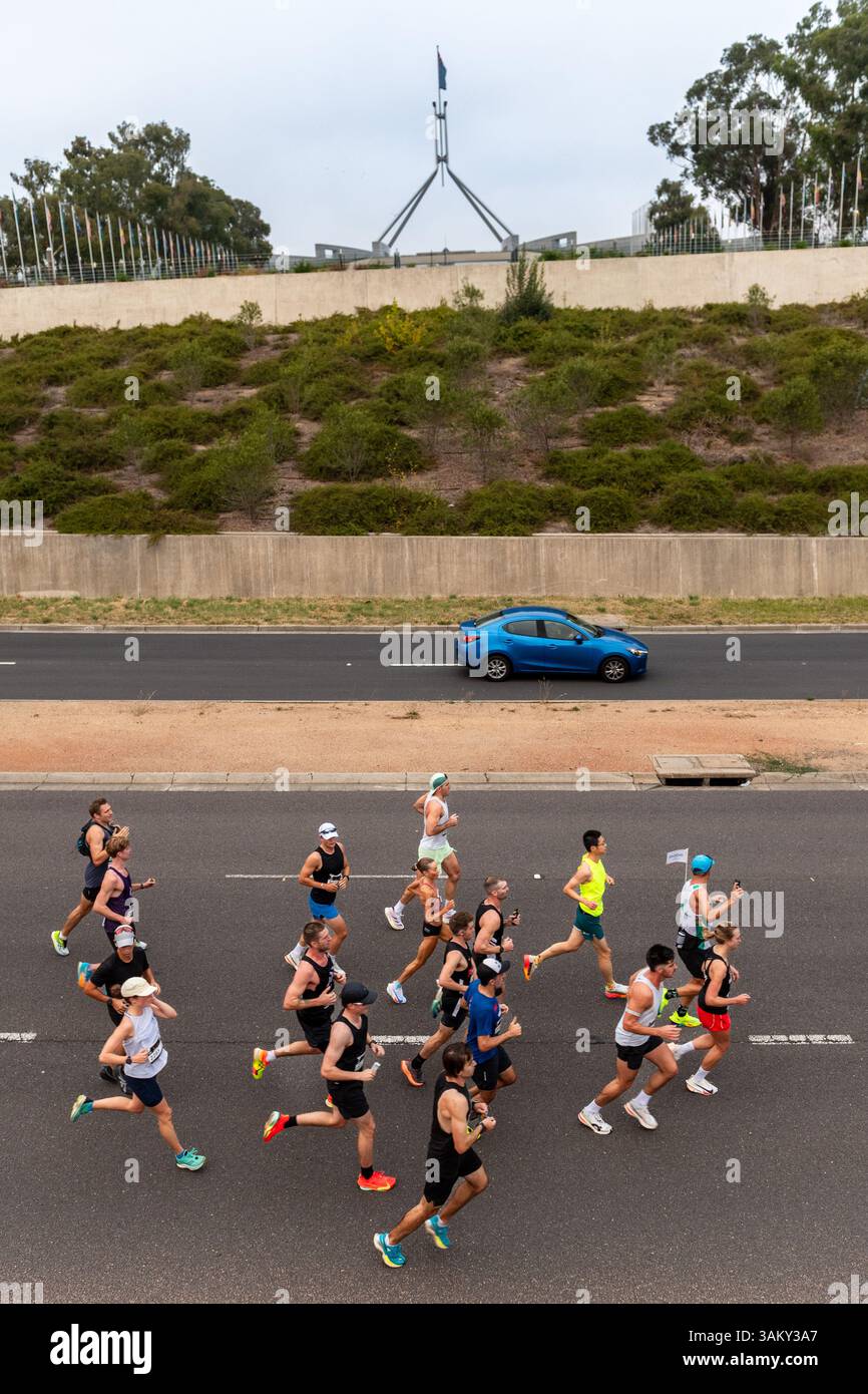 Marathon participants make their way past Australia's Parliament House ...