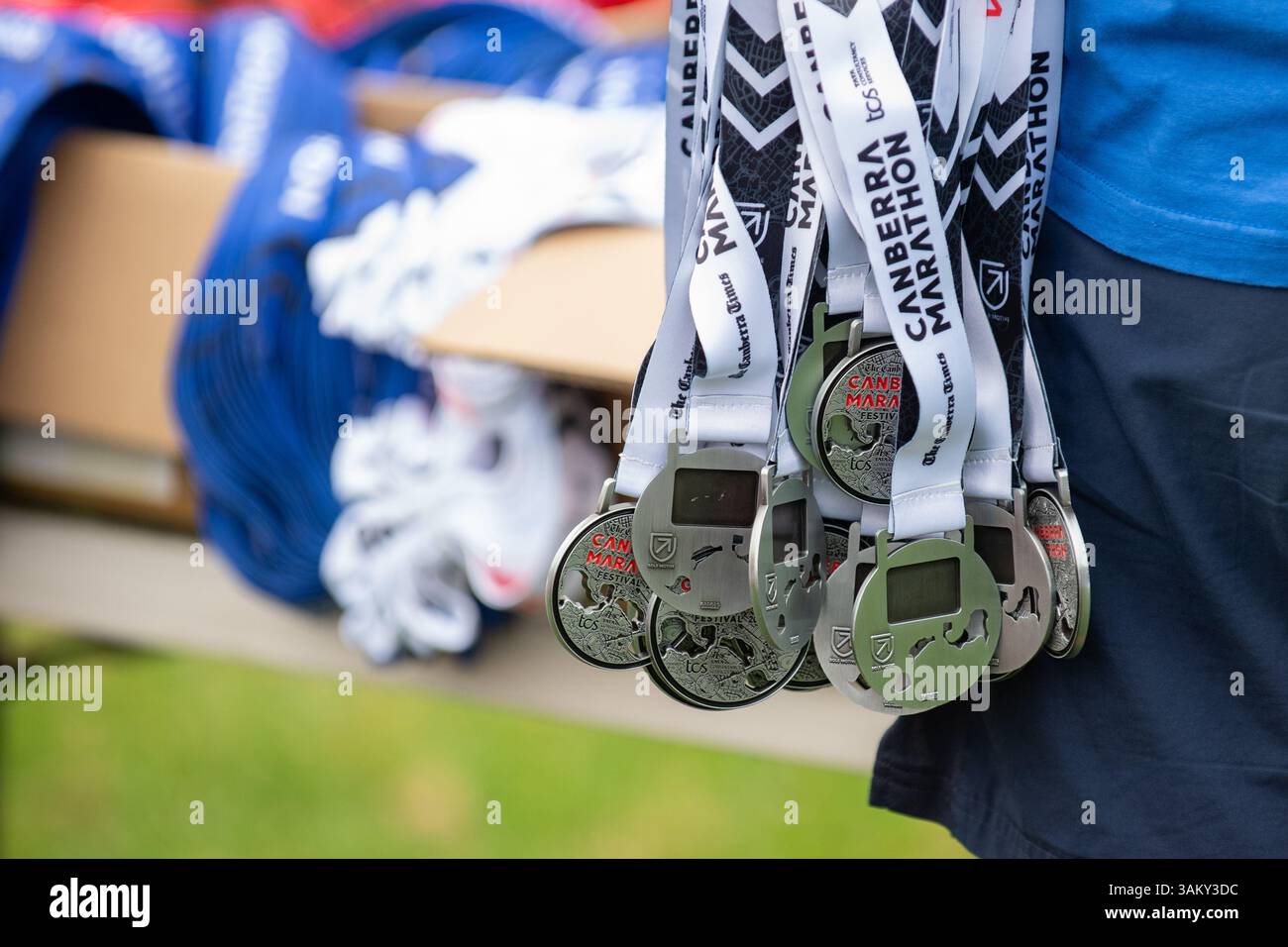 An official holds a large bundle of finisher medals, ready to present ...