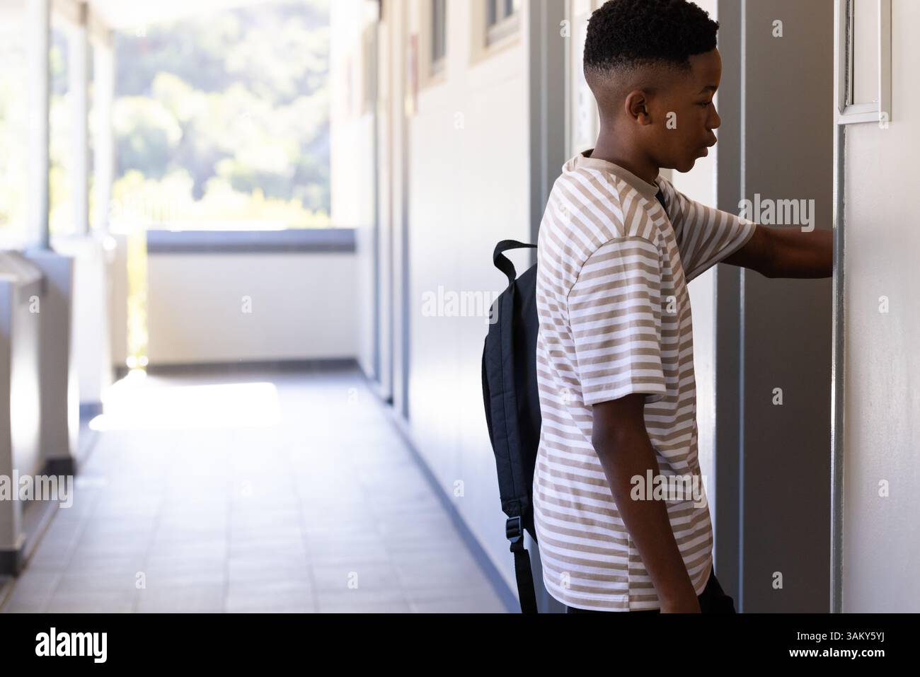 Opening locker, student with backpack in school hallway, preparing for ...
