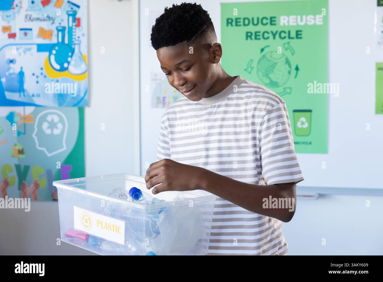 Sorting plastic items into recycling bin, boy in school promoting ...