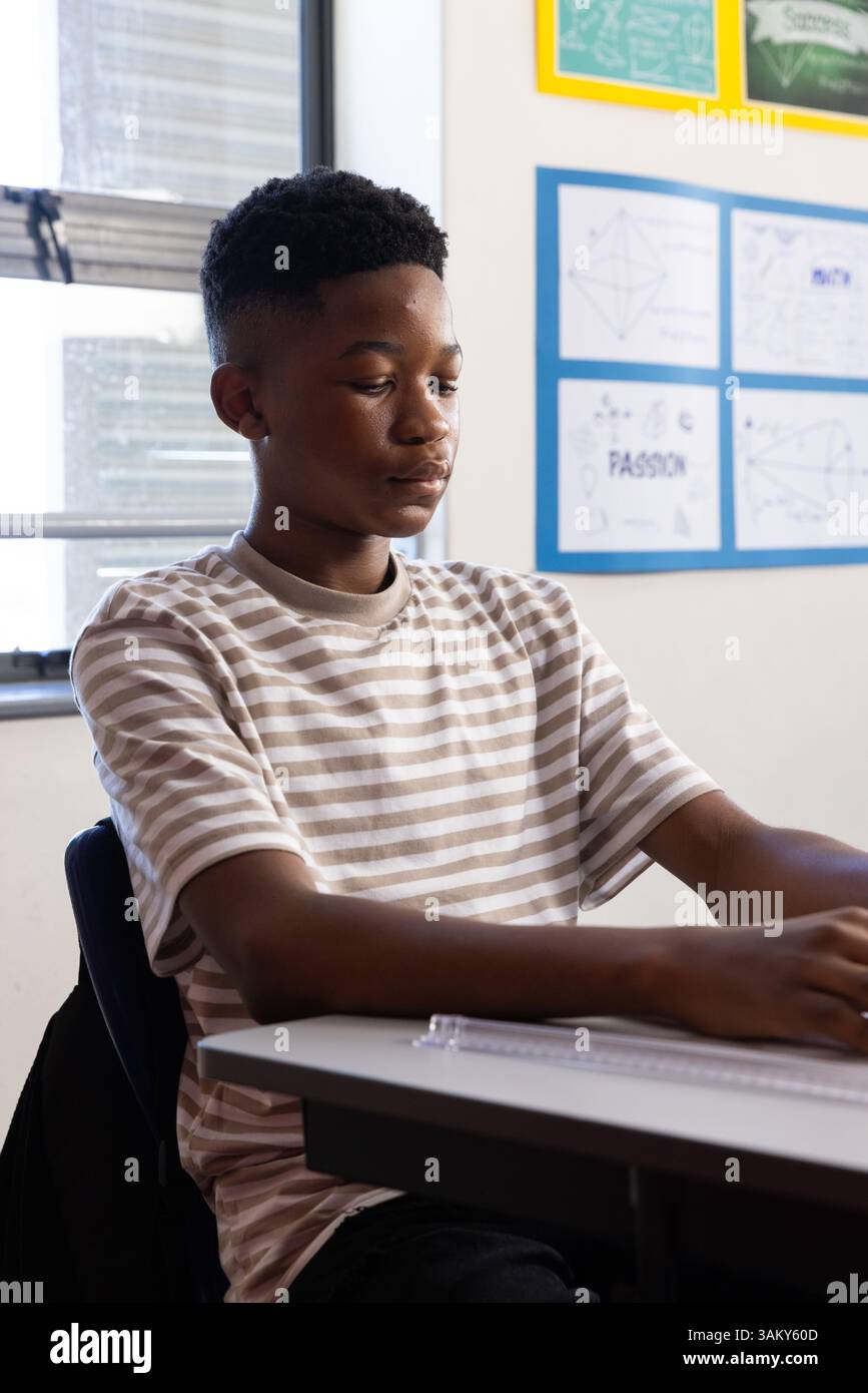 In school, boy sitting at desk focusing on classroom work Stock Photo ...