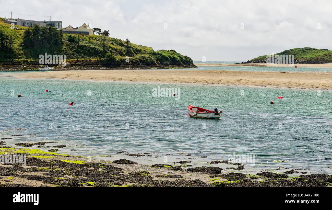 A serene afternoon at Middle Ring Bay Beach, where a small boat glides ...