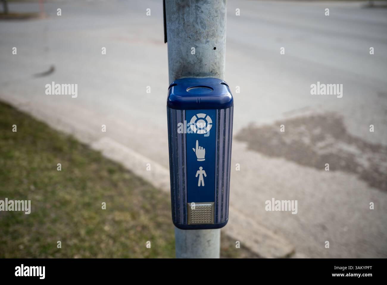Pedestrian crossing button mounted on a metal pole beside a road Stock ...