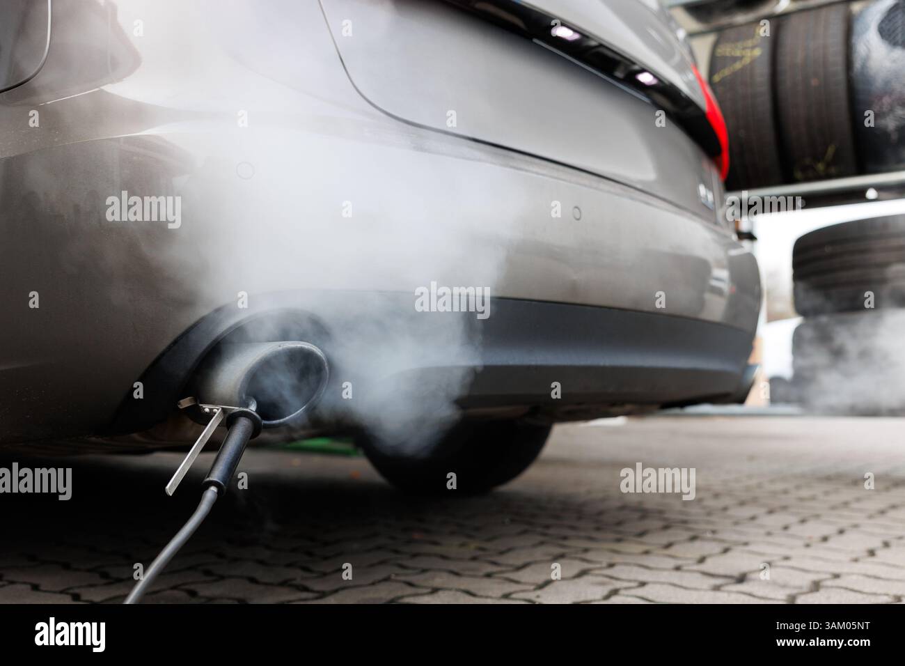 Car exhaust pipe emits dense smoke during emission test on city ...