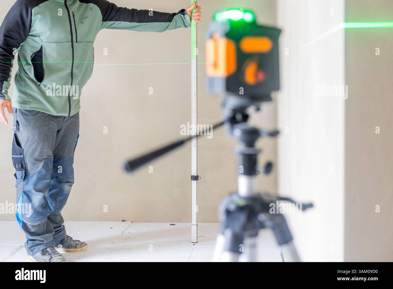 Construction worker using laser level and measuring rod on site Stock ...