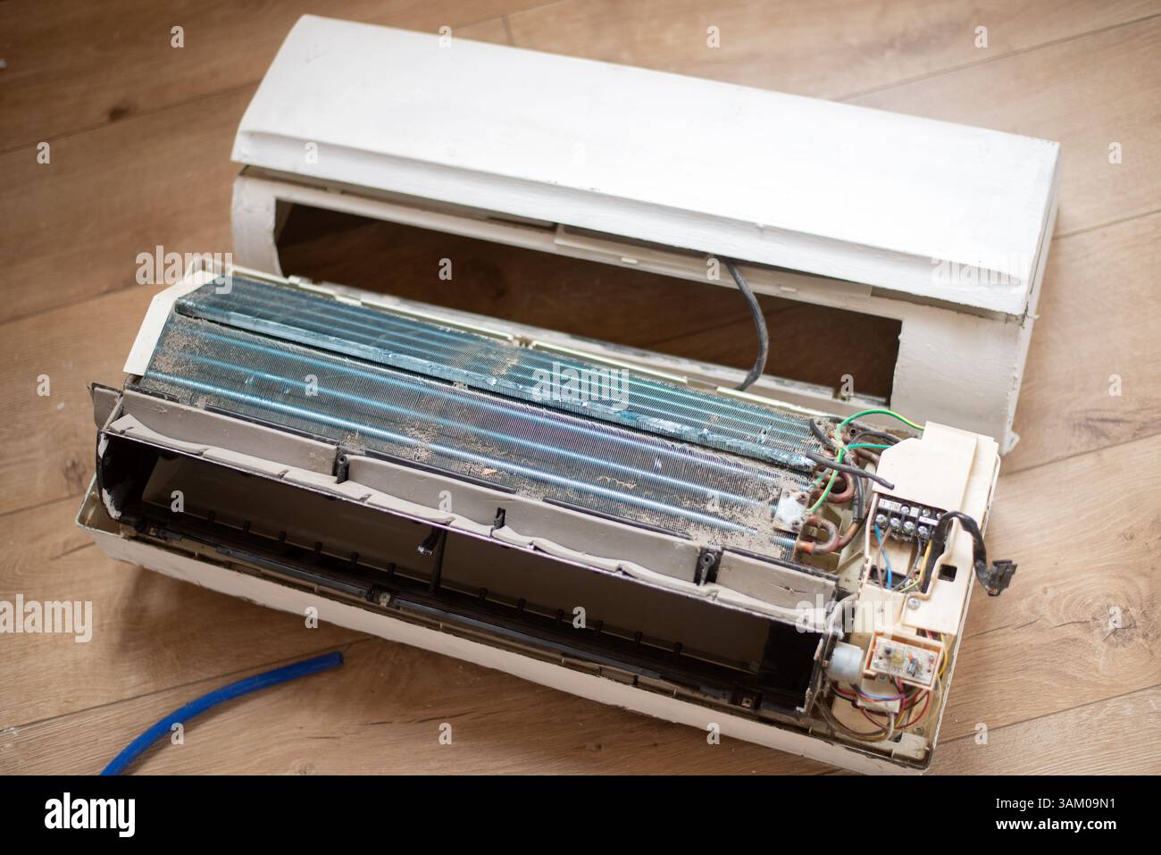 Dirty and disassembled wall-mounted air conditioner unit, showing internal components and dust ...
