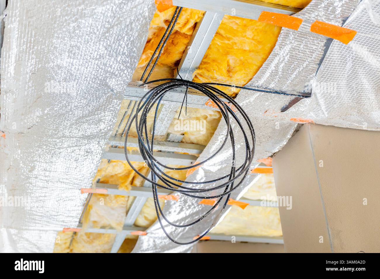 Electrical wiring and insulation being installed in building ...