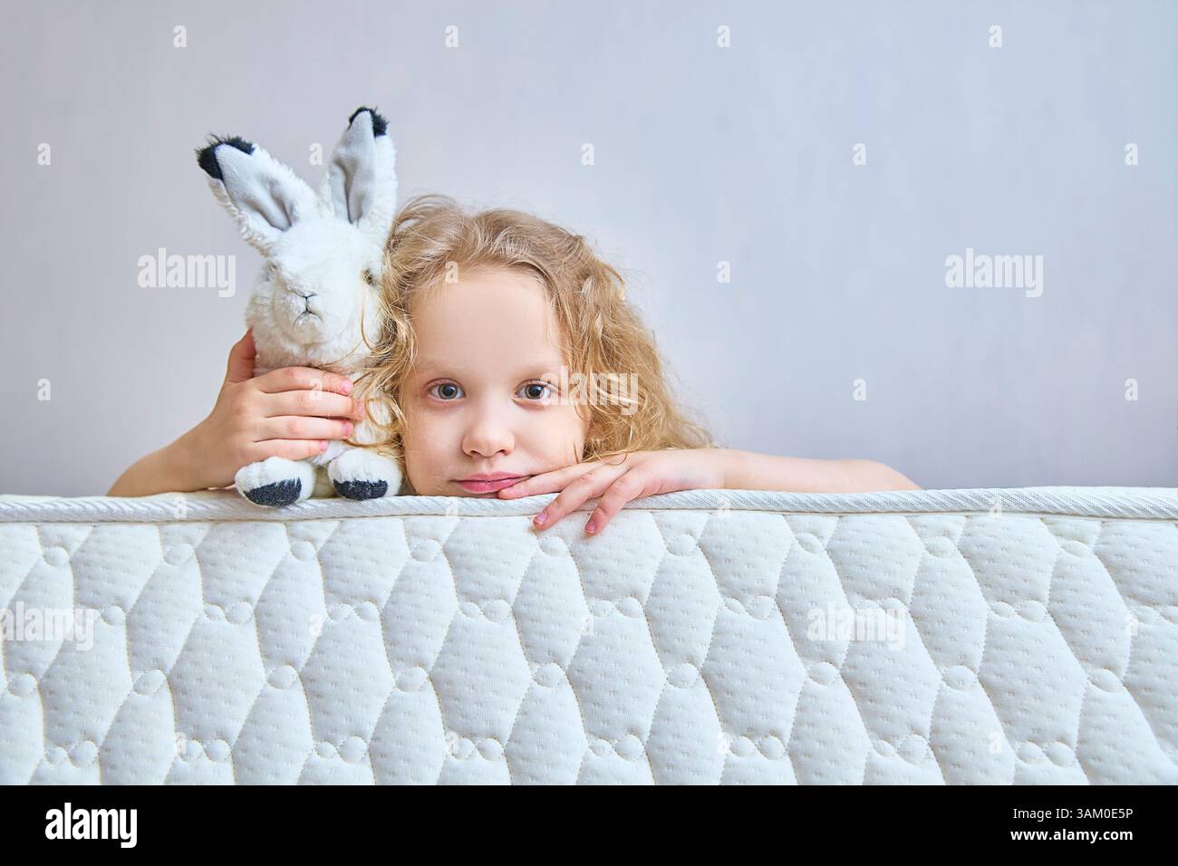 Radiant curiosity shines from a sweet child peeking over a crisp, white ...