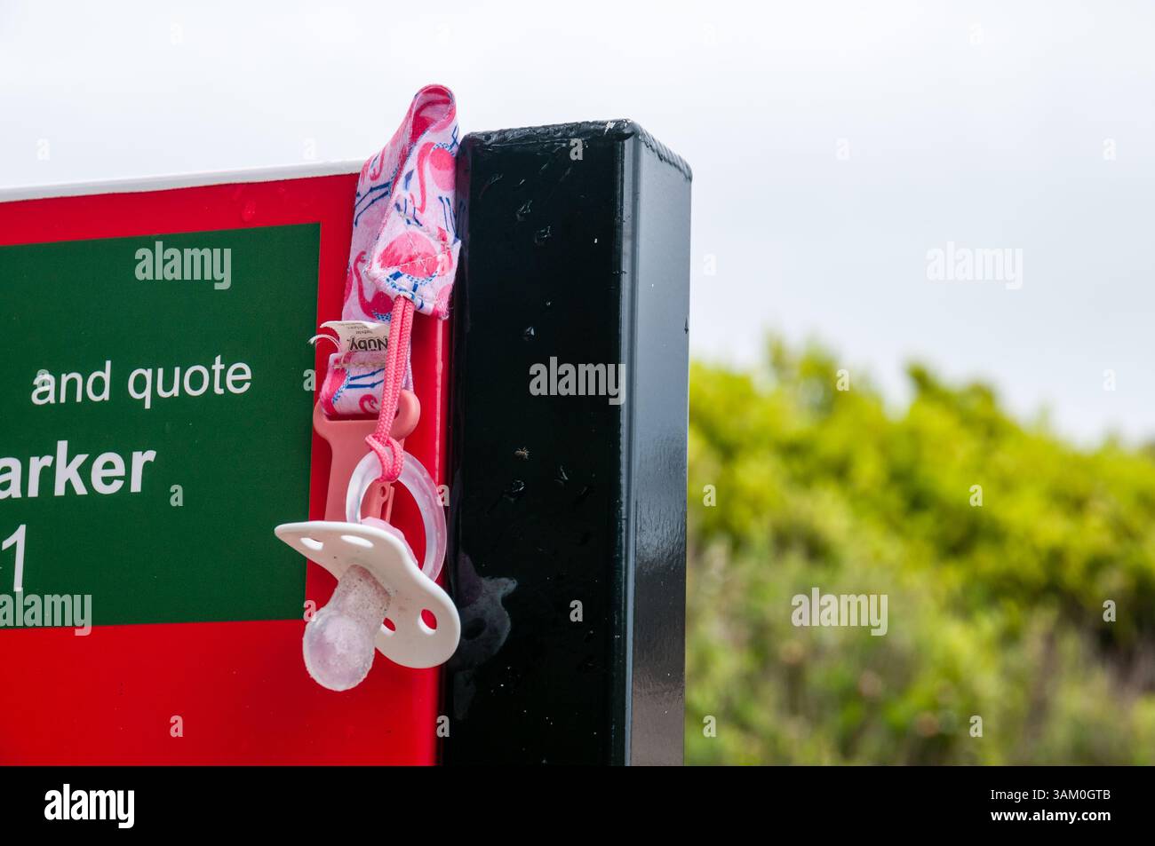lost pacifier hanging from an information sign Stock Photo - Alamy