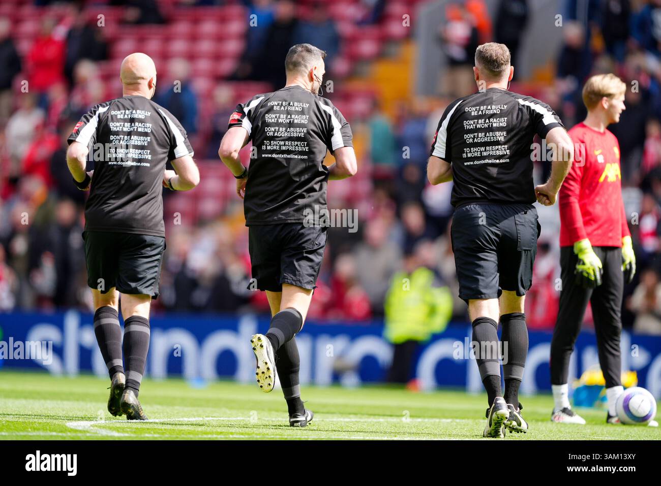 The referee and his assistants wearing "Don't X The Line" warm up ...