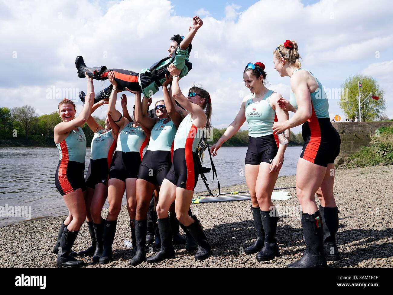 The Cambridge Women's team lift cox Jack Nicholas after winning The 79th CHANEL J12 Women's Boat ...