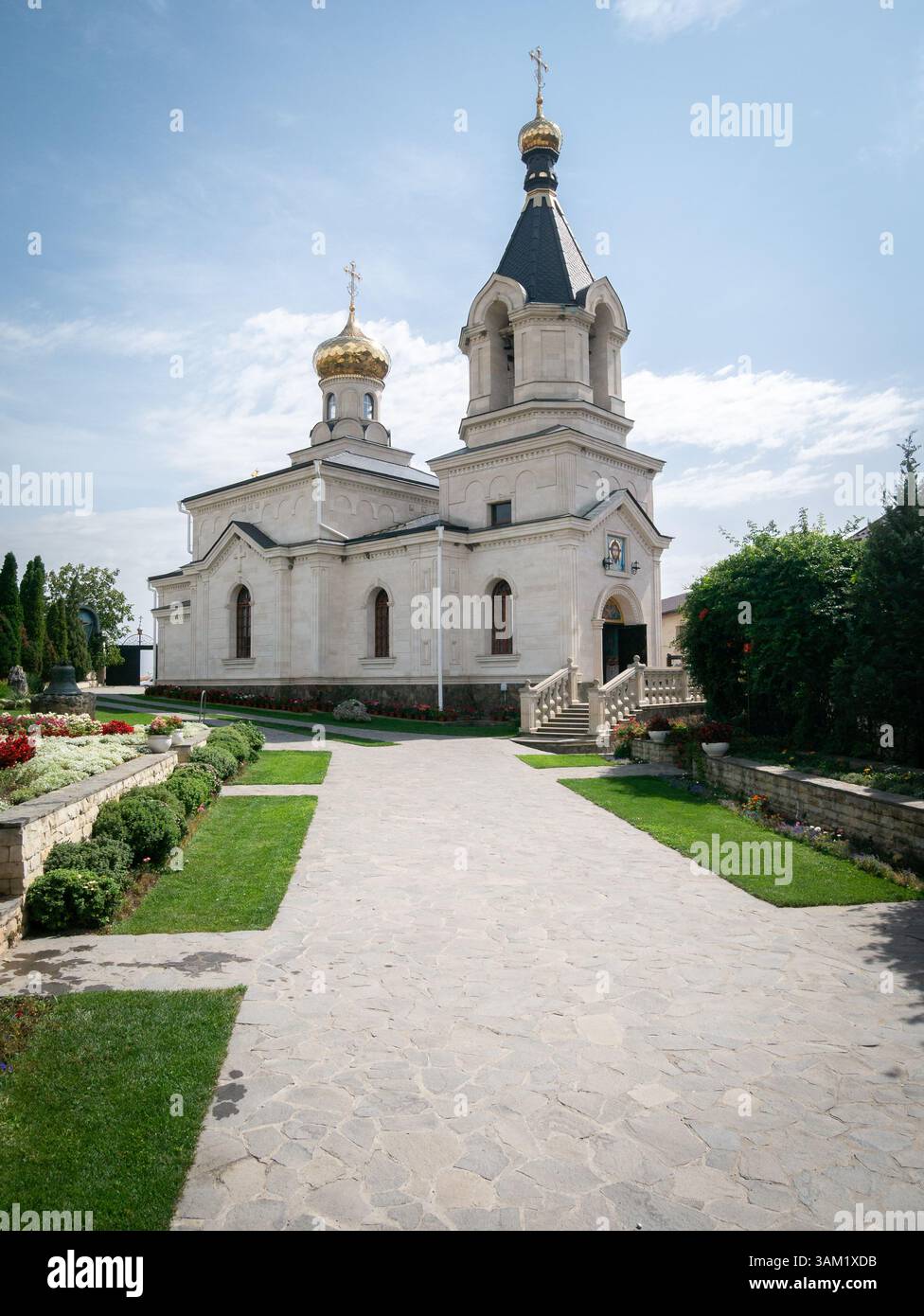 Vertical shot of old orthodox church surrounded by gardens, Moldova ...