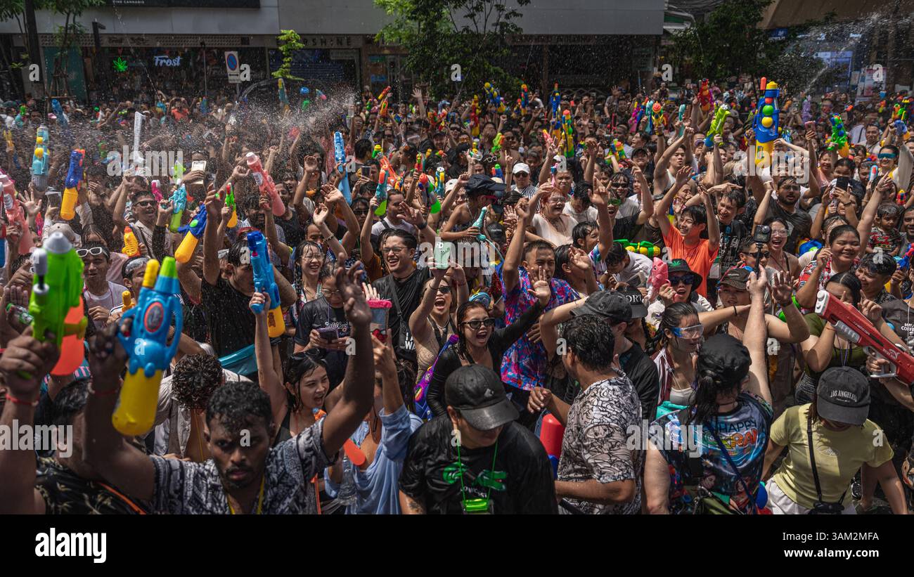 People particpate in water gun fights and dance to music along Silom ...