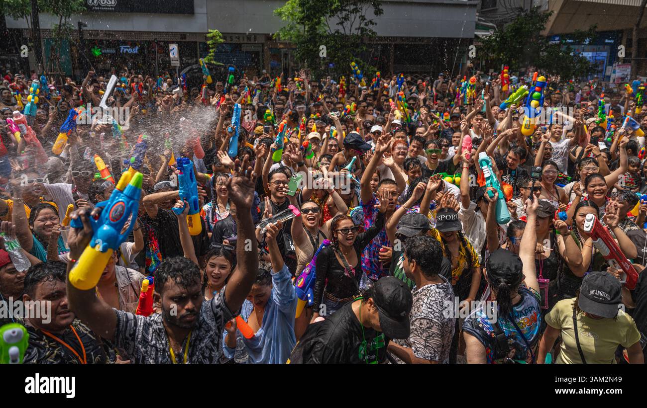 People particpate in water gun fights and dance to music along Silom ...