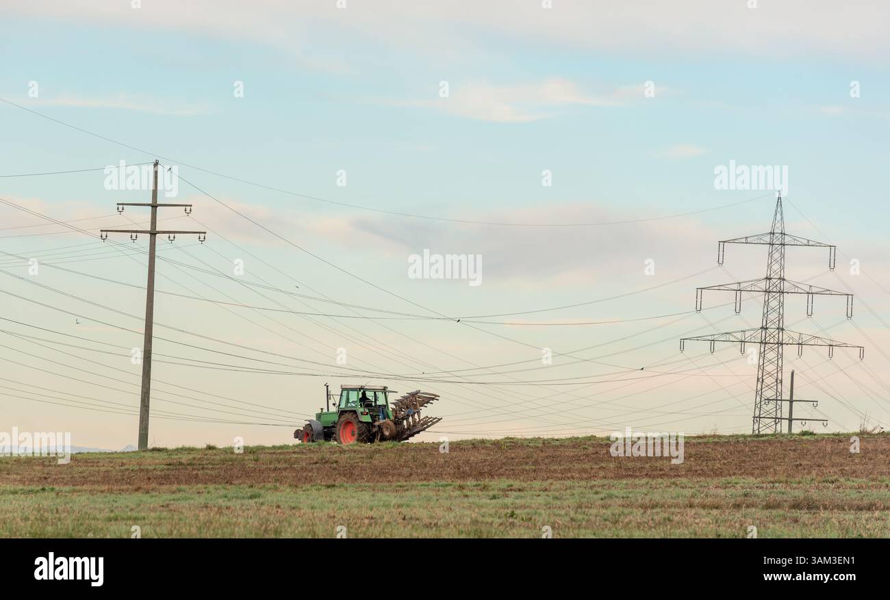 Side view with a single tractor working the agricultural fields in the ...