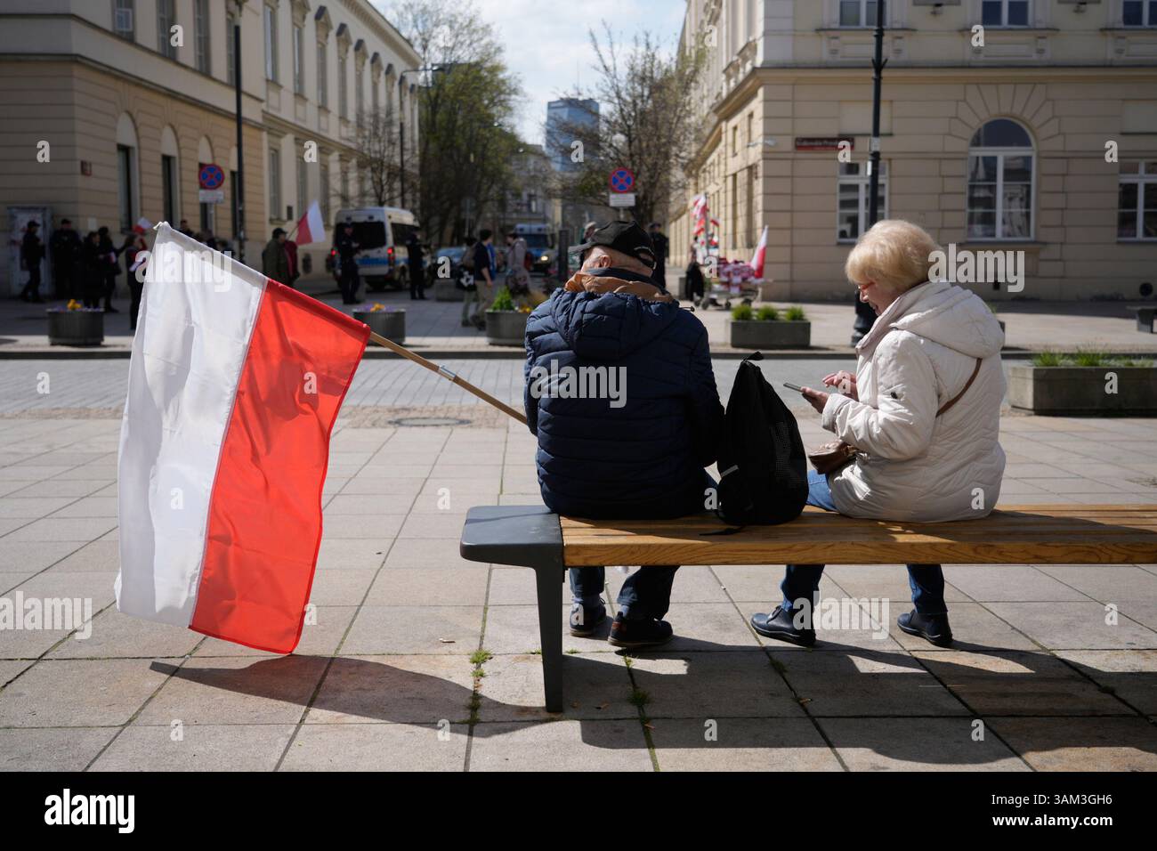 A man and a woman sit on a bench on the Krakowskie Przedmiescie street ...